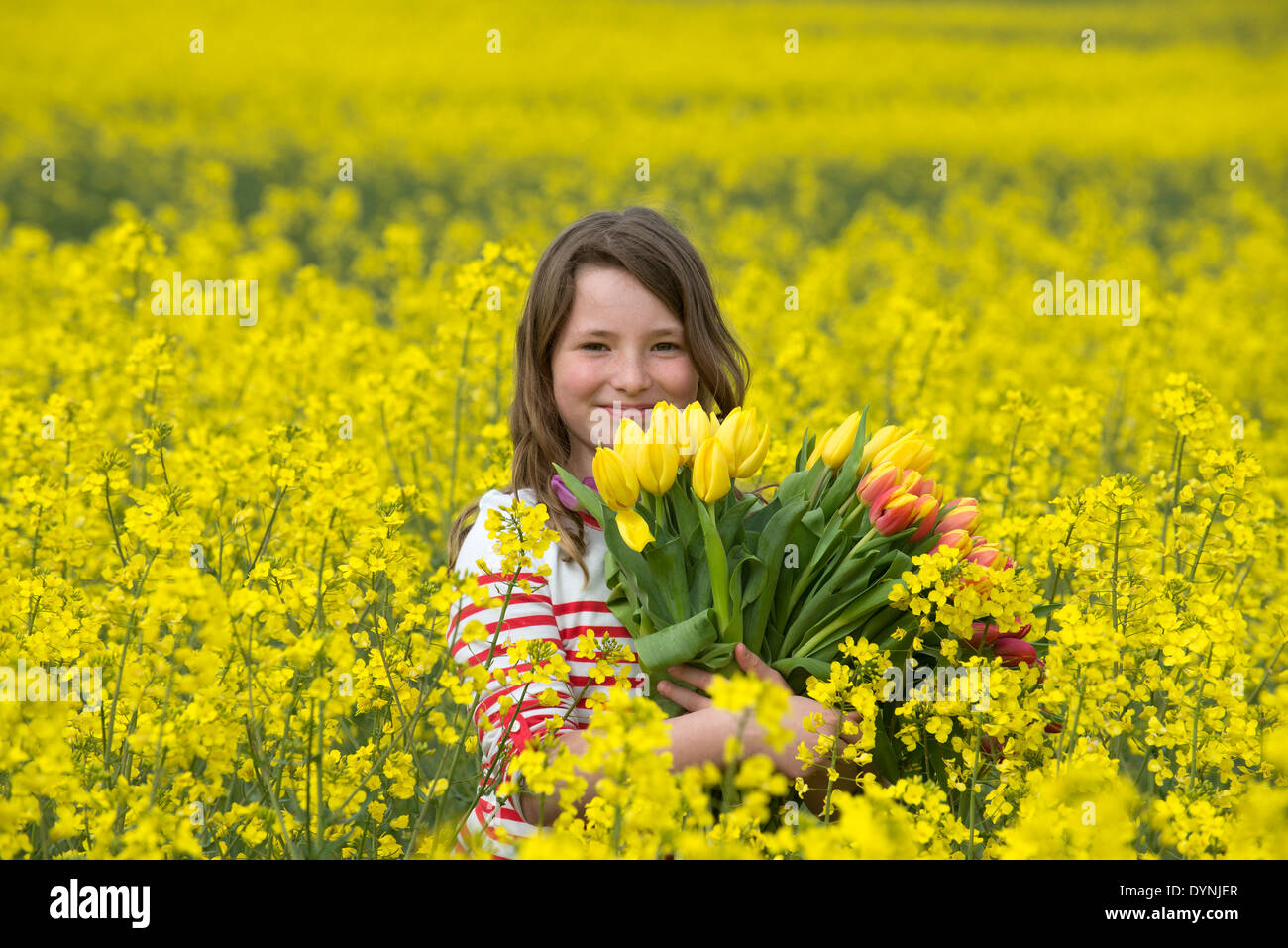 Young girl holding a bunch of Spring flowers in the English countryside ...