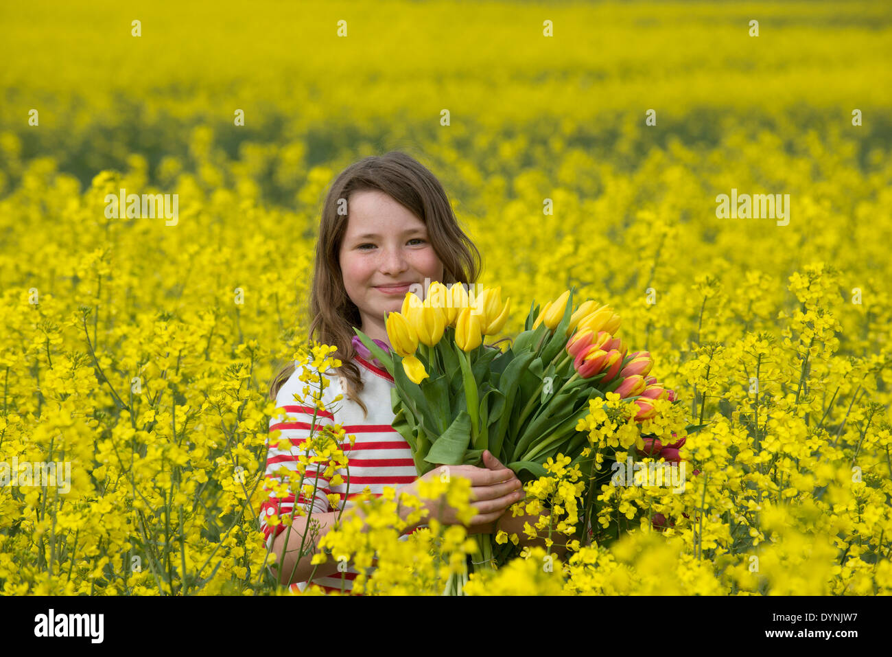 Young girl holding a bunch of Spring flowers in the English countryside ...