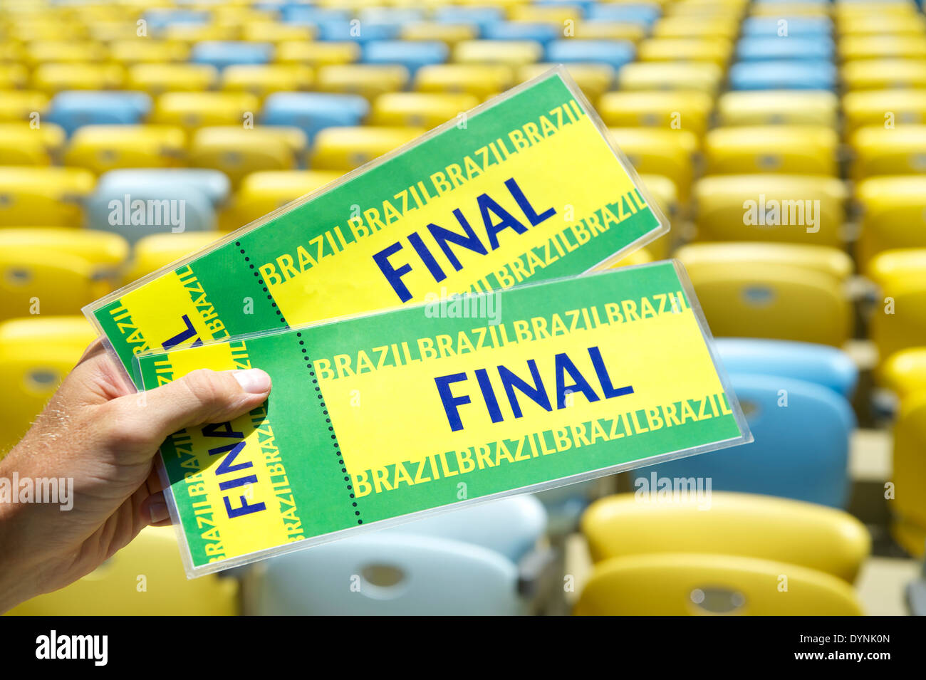 Soccer fan holding two Brazil final tickets in front of empty stadium ...