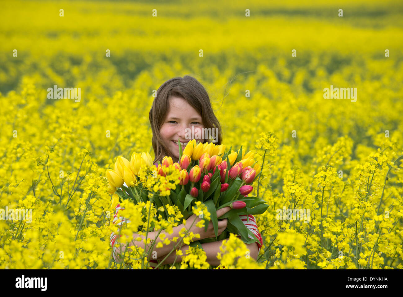 Young girl holding a bunch of Spring flowers in the English countryside ...