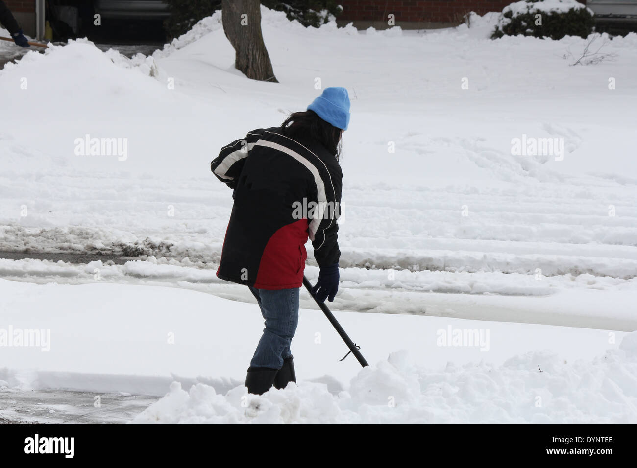 Lady shoveling the deep snow off her driveway after a snow storm Stock ...