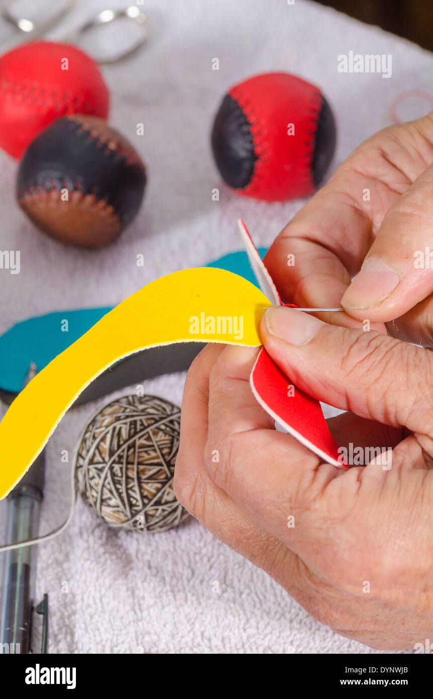Sewing small leather pieces into a traditional pelota ball Stock Photo ...