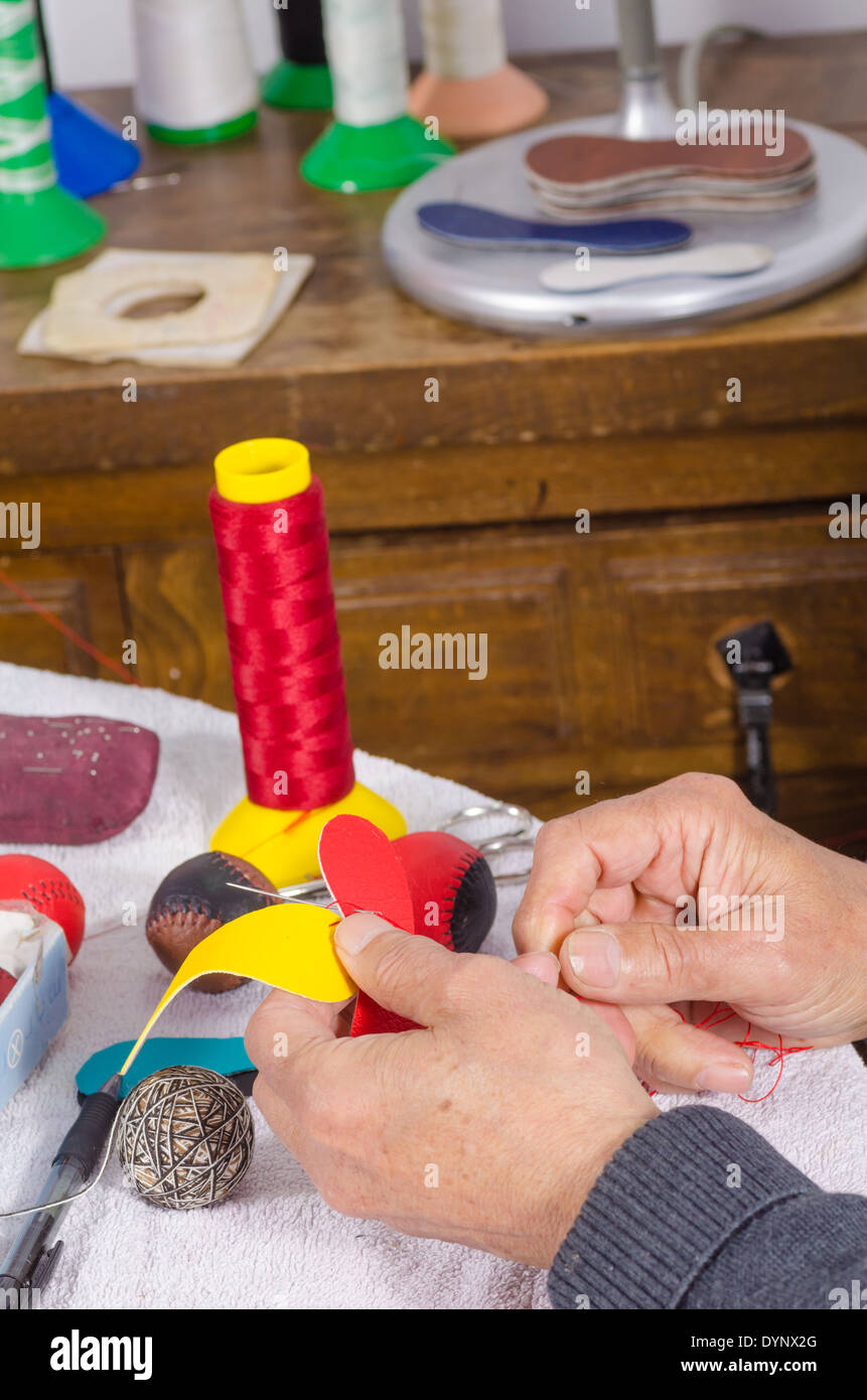 Sewing small leather pieces into a traditional pelota ball Stock Photo ...