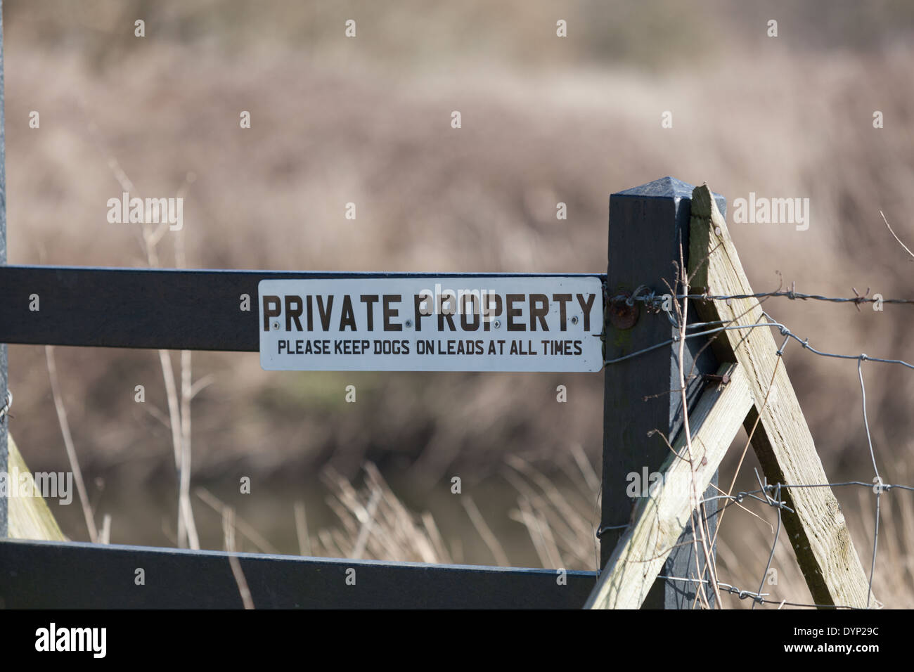 A sign on a field gate stating "Private Property please keep dogs on ...