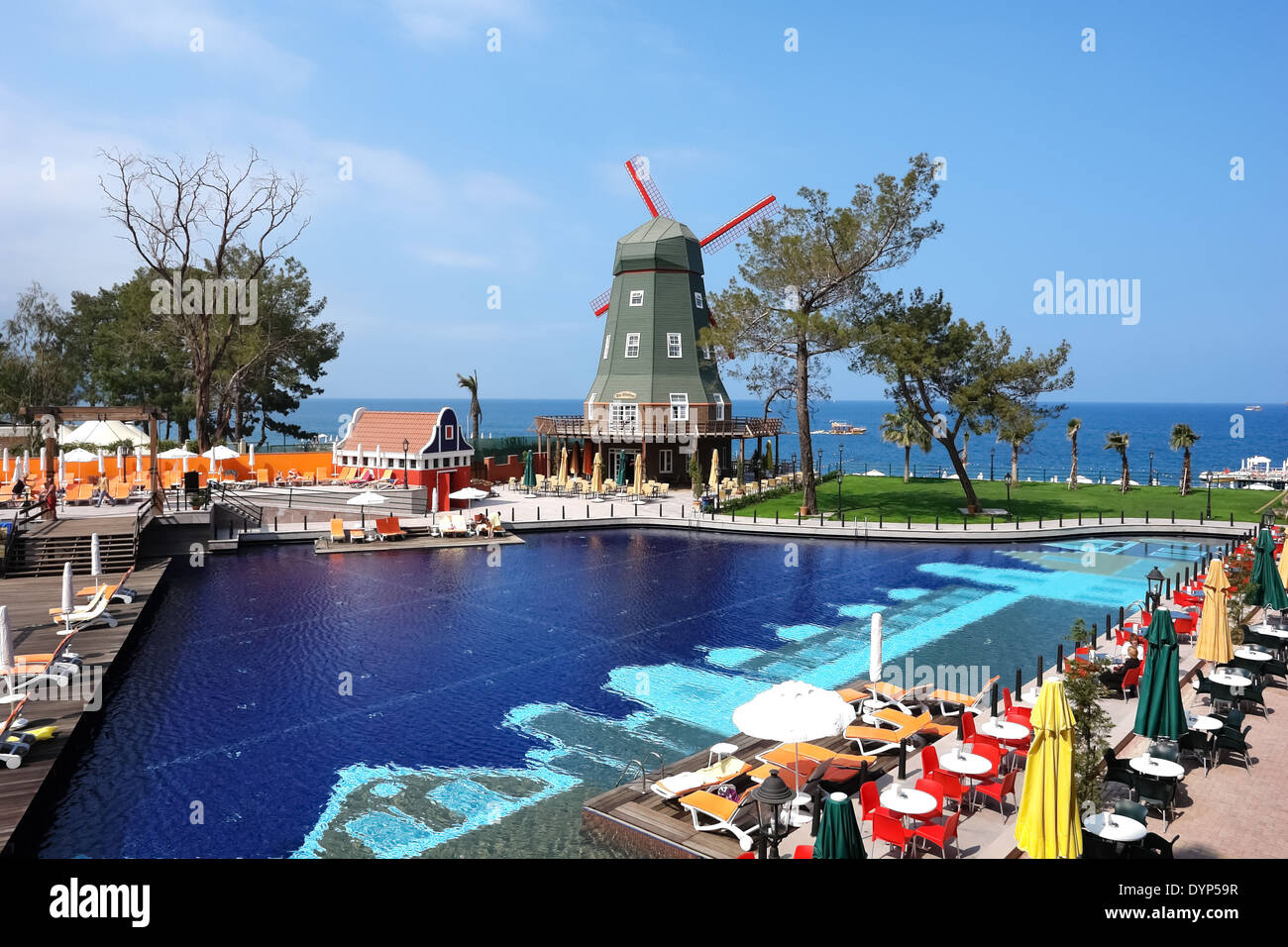 The windmill and swimming pool in luxury turkish hotel Stock Photo - Alamy