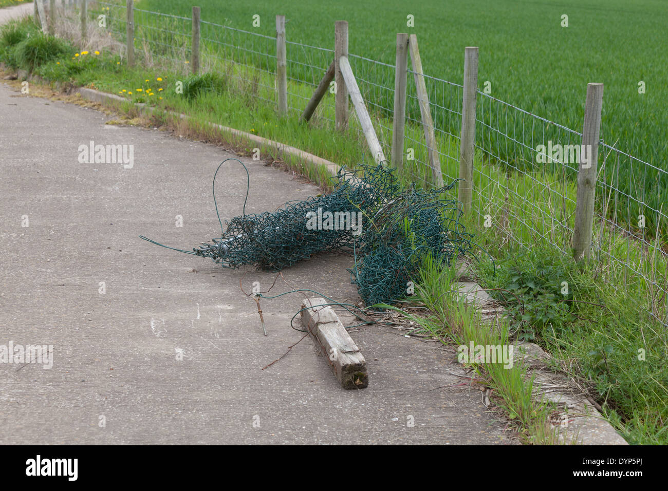Fly-tipped chainlink fencing dumped next to farmland Stock Photo - Alamy