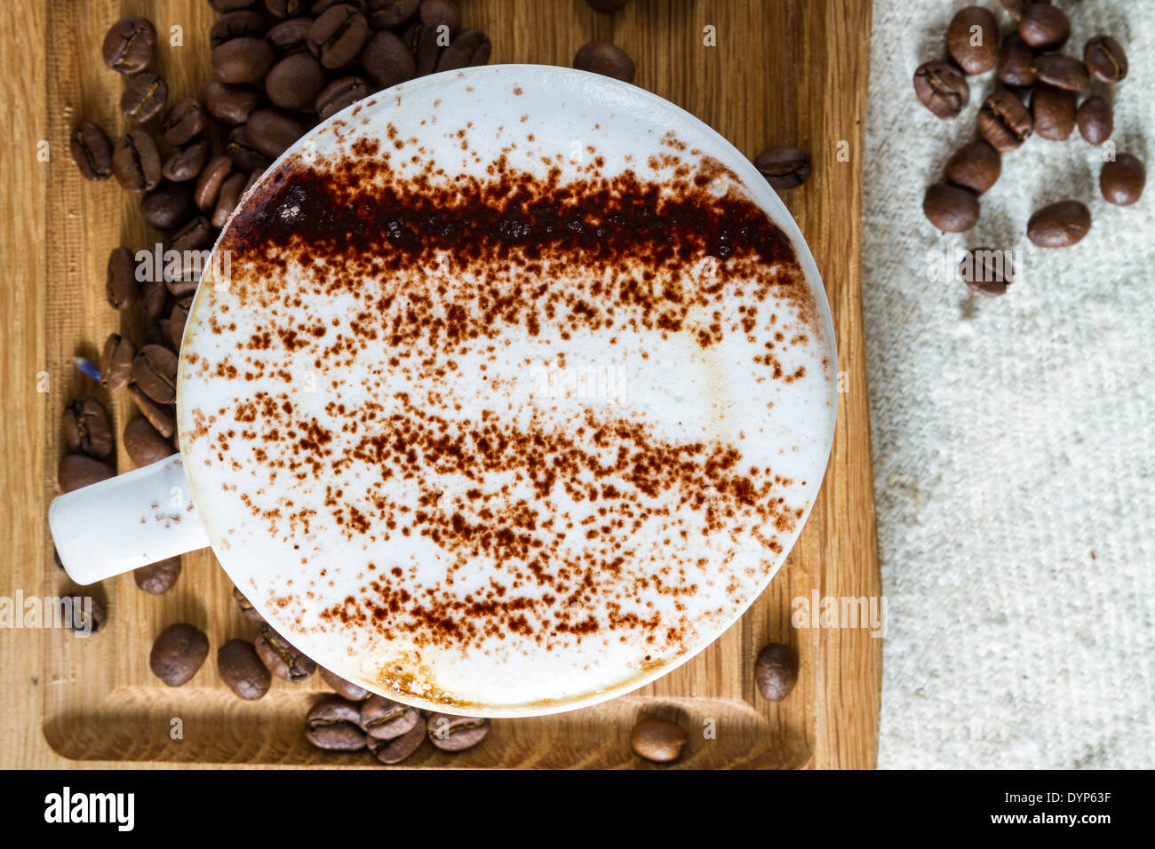 Frothy cappuccino with cocoa powder on top and fresh beans in the ...