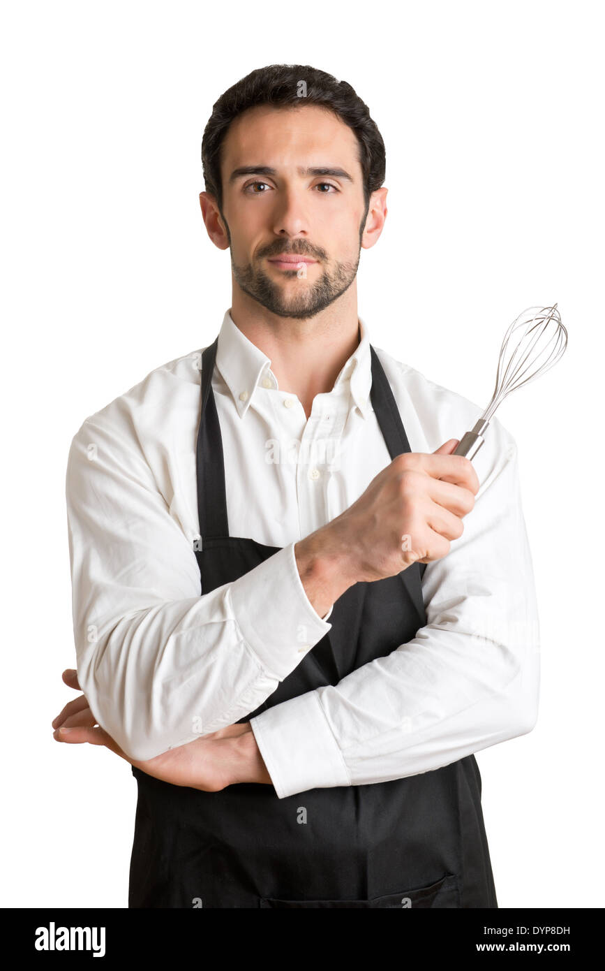Male cooker with a black apron, smiling and holding a egg-beater ...