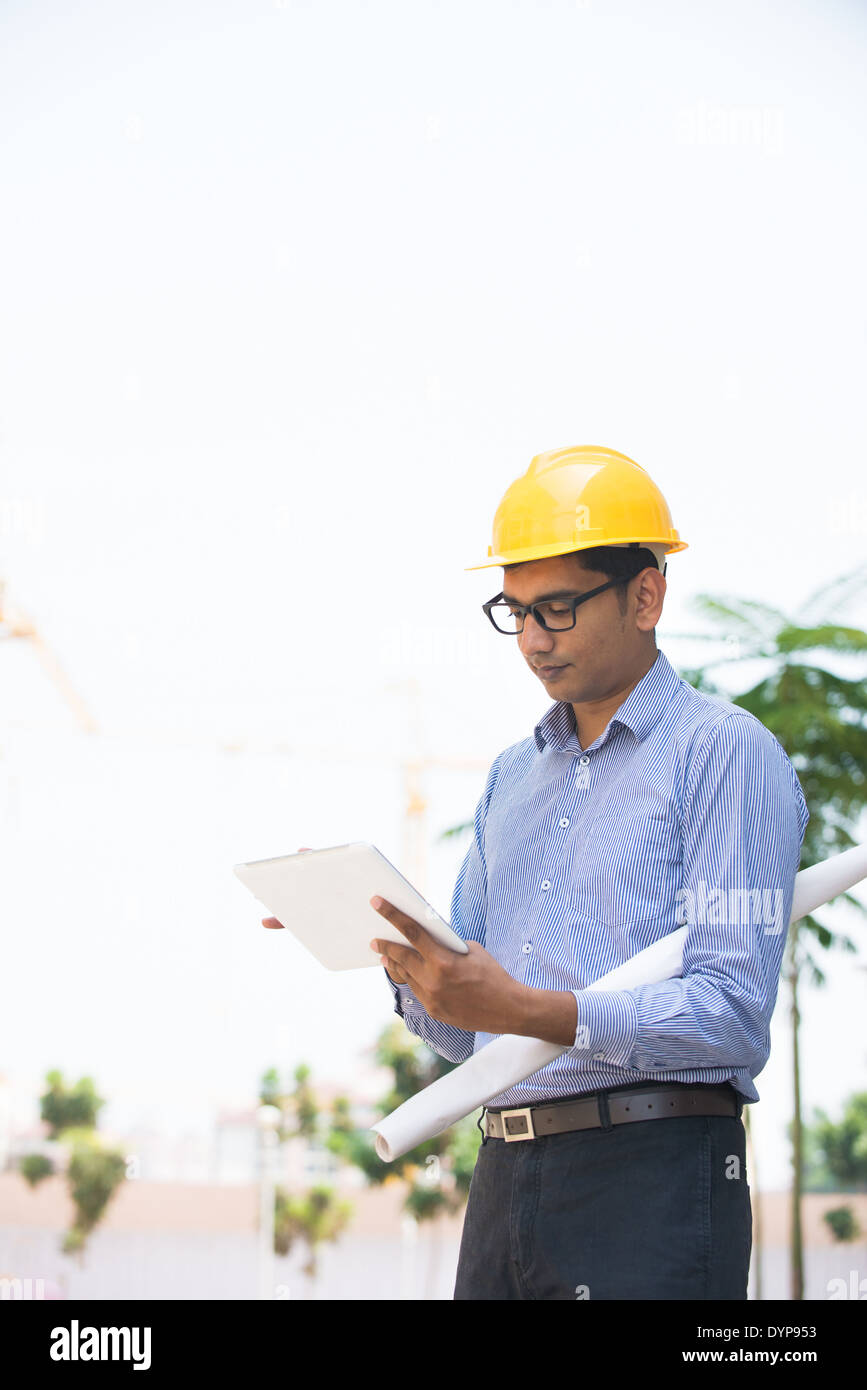 indian male architect inspecting site with construction background ...