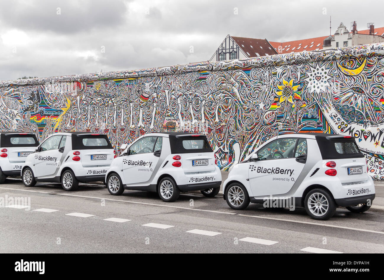 Mercedes Smart cars in front of Berlin Wall Stock Photo - Alamy