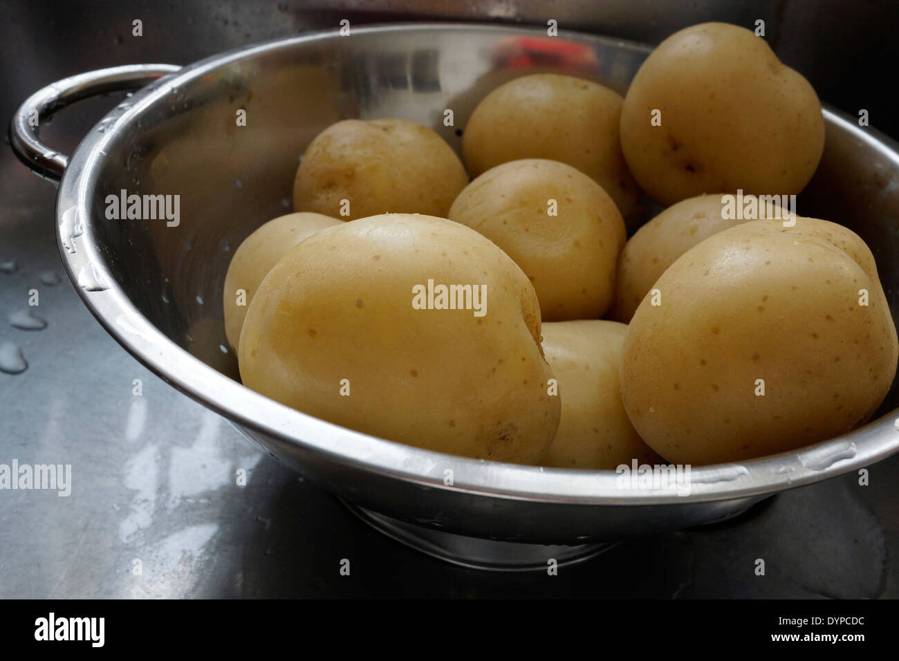 Unpeeled boiled potatoes cooling down in colander Stock Photo - Alamy