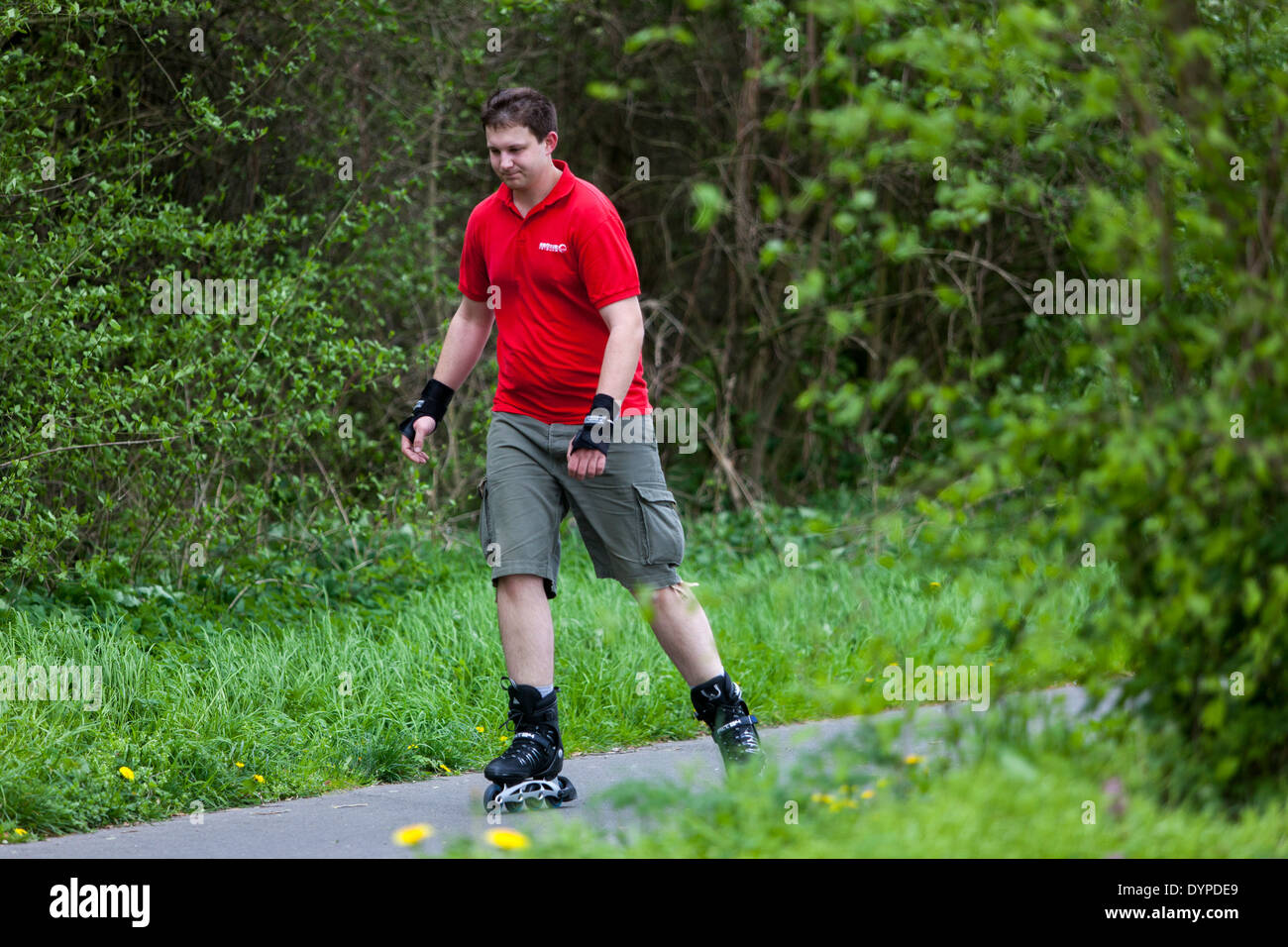 Inline skating man in a park path Stock Photo - Alamy