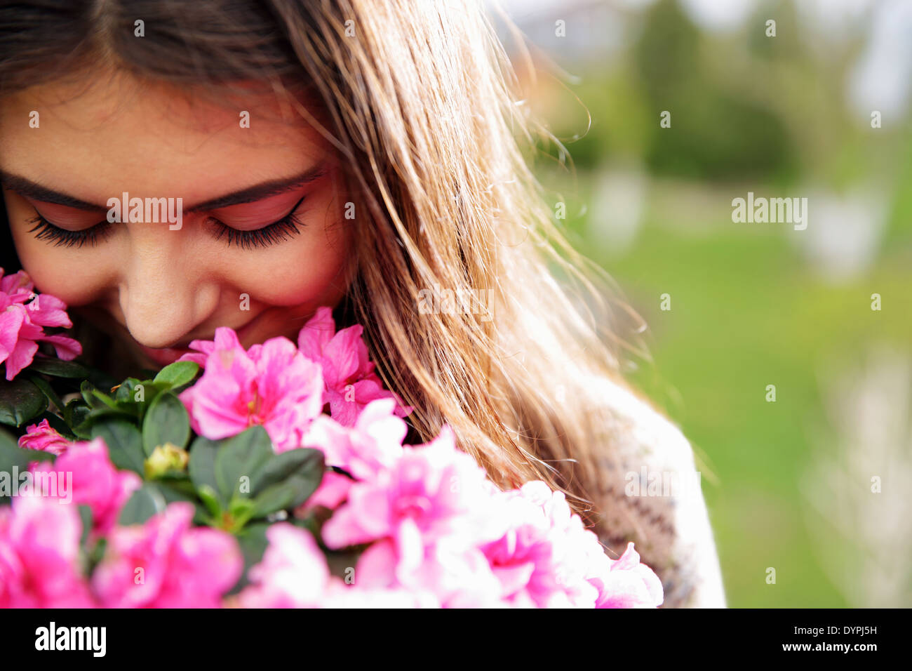 Woman smelling pink flowers hi-res stock photography and images - Alamy