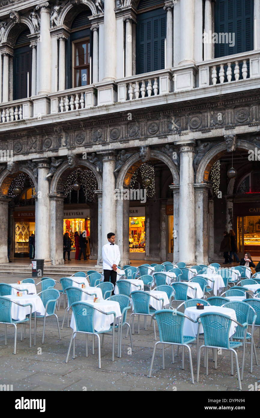 Quiet evening scene on St Mark's Square, Venice with waiter standing ...