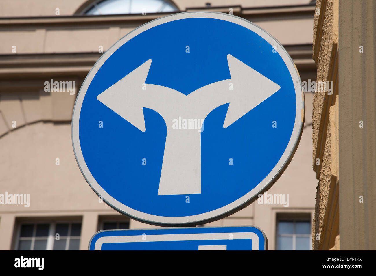 Blue Two Directions Traffic Sign in Urban Setting Stock Photo - Alamy