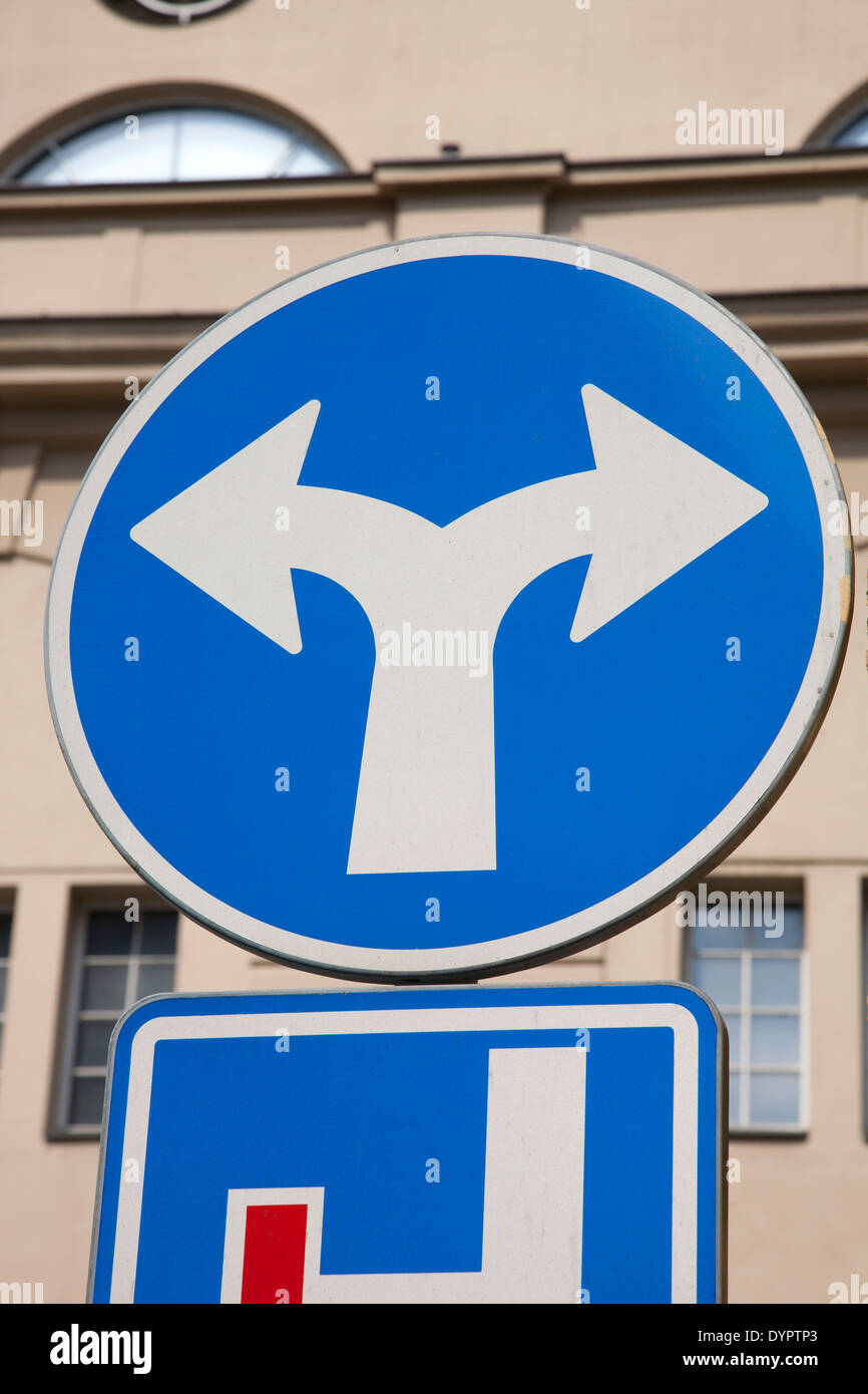 Blue Two Directions Traffic Sign in Urban Setting Stock Photo - Alamy