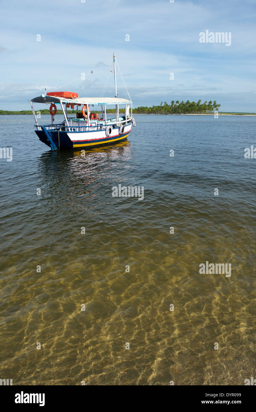 Brazilian boat floating off shore anchored in shallow waters on a ...