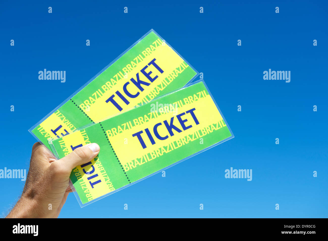 Hand holding two Brazil tickets against bright tropical blue sky Stock ...