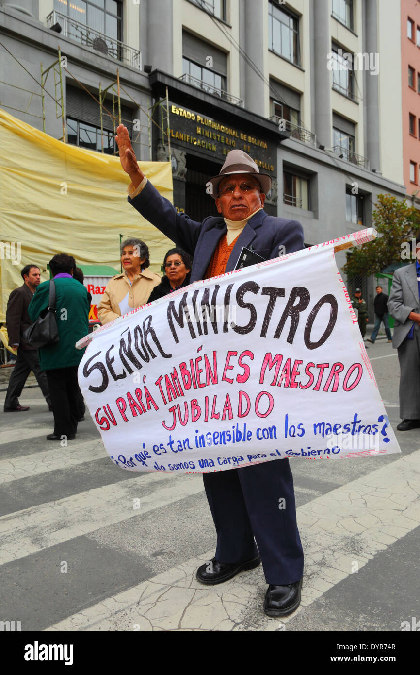 A retired male teacher carries a banner during a protest march ...