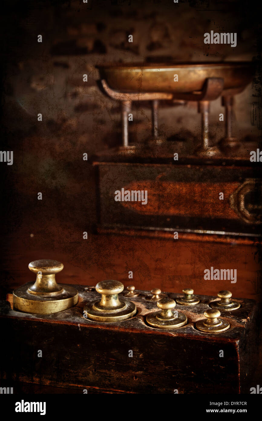 Antique brass weights with scales in the background. Distressed texture ...