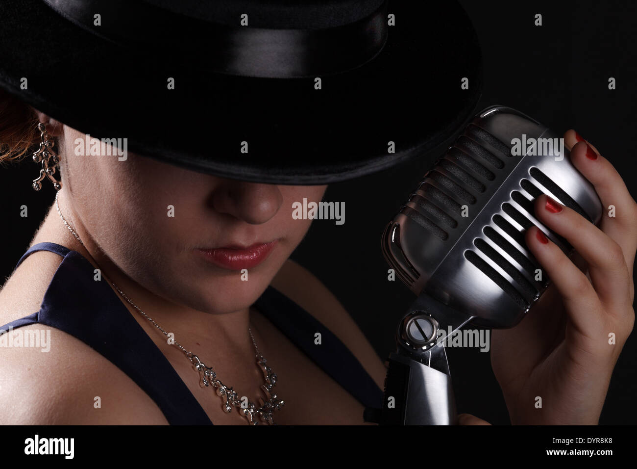 Beautiful jazz singing woman with fedora and retro style microphone ...