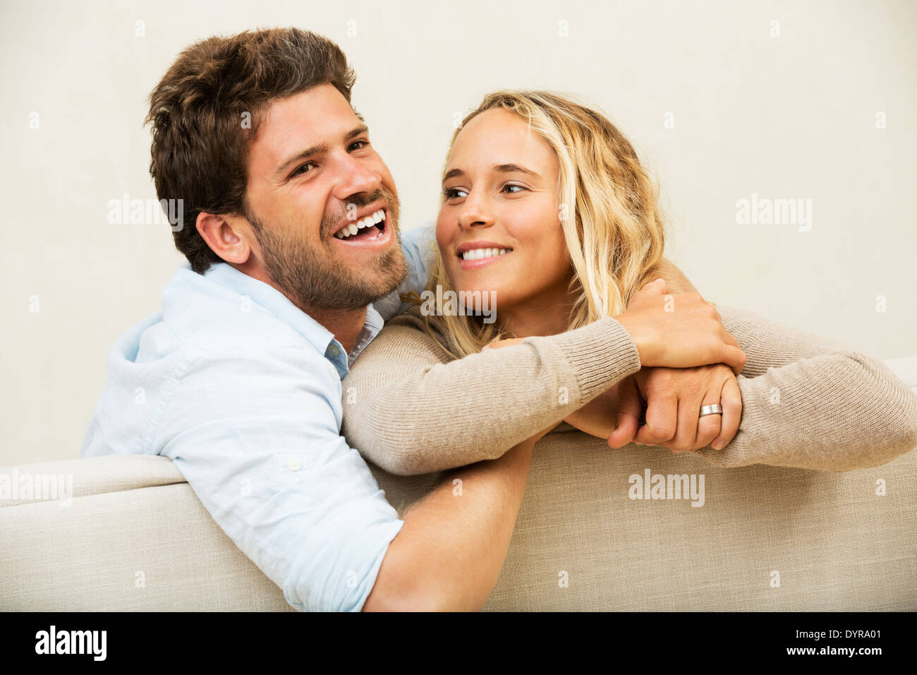 Happy young couple at home relaxing on the sofa Stock Photo - Alamy