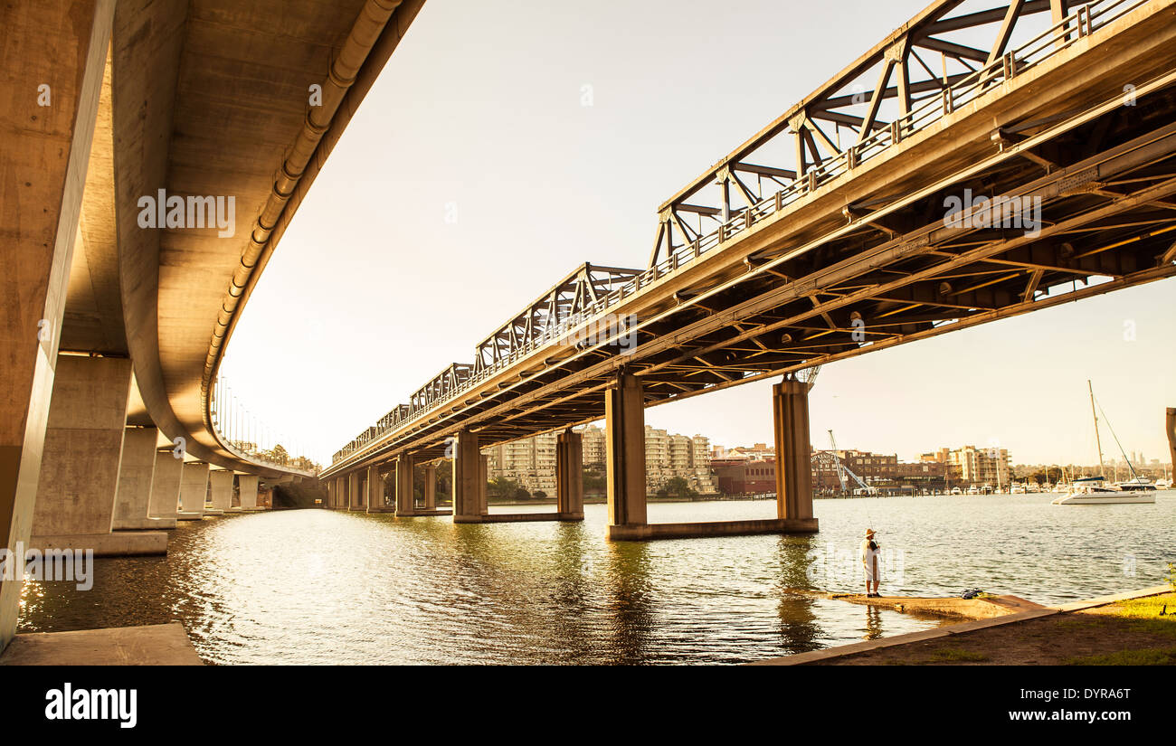 A older iron road bridge next to a modern concrete one in Sydney with a ...