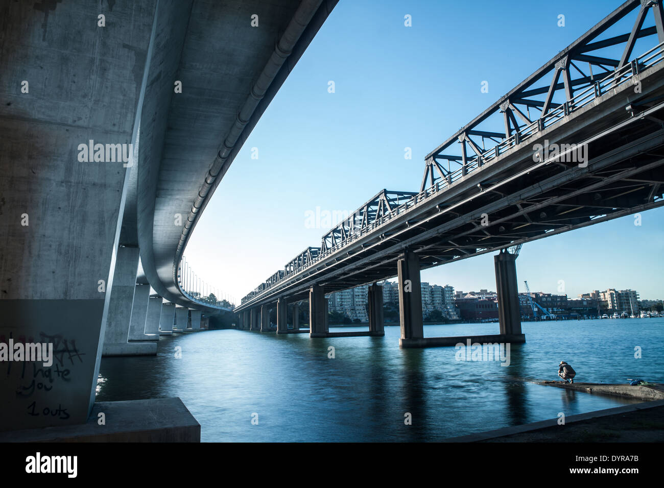 A older iron road bridge next to a modern concrete one in Sydney Stock ...