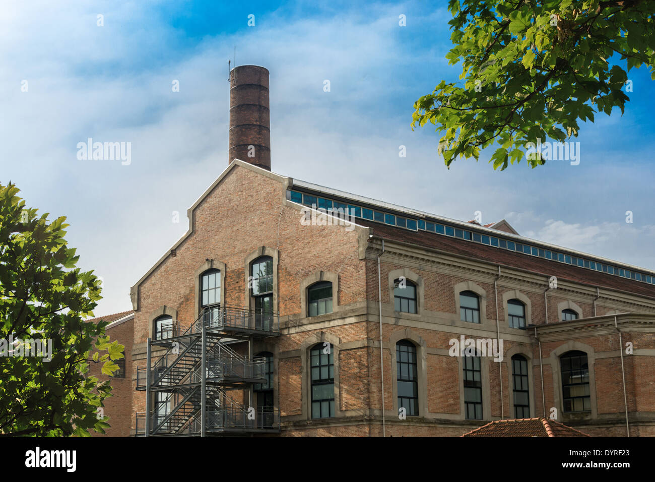 Industrial building with a tower and trees Stock Photo - Alamy