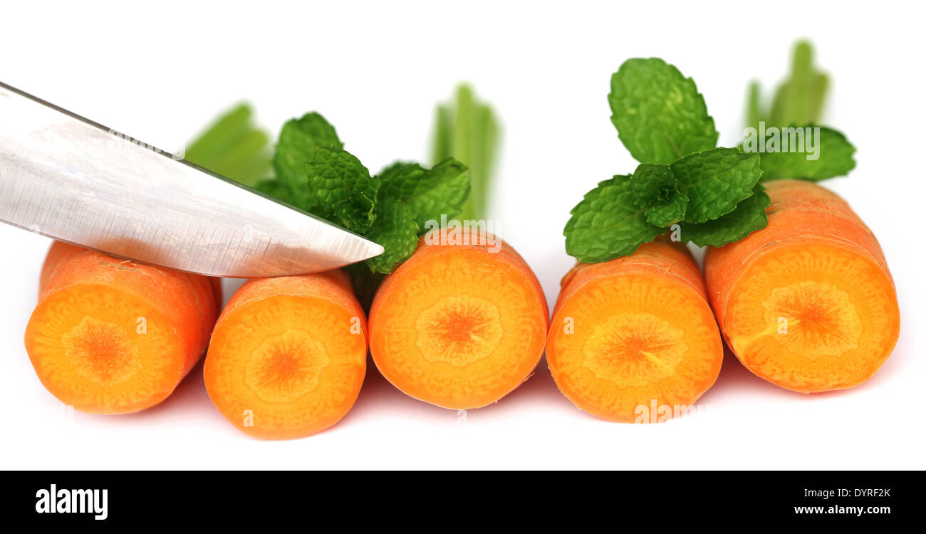 Cutting carrot with a kitchen knife over white background Stock Photo ...