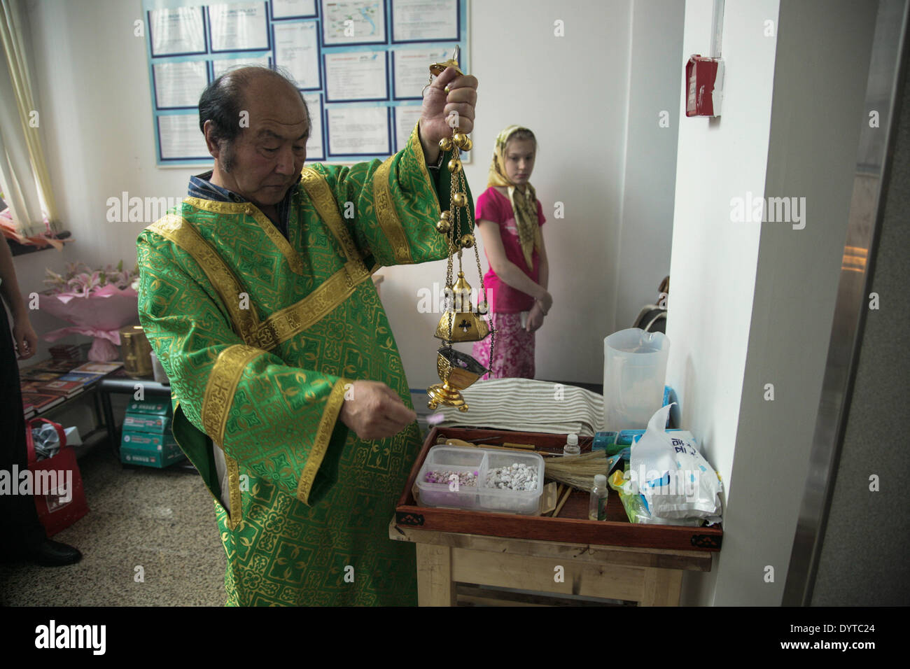 A disciple watch a religious staff refill the incense in a Orthodox ...