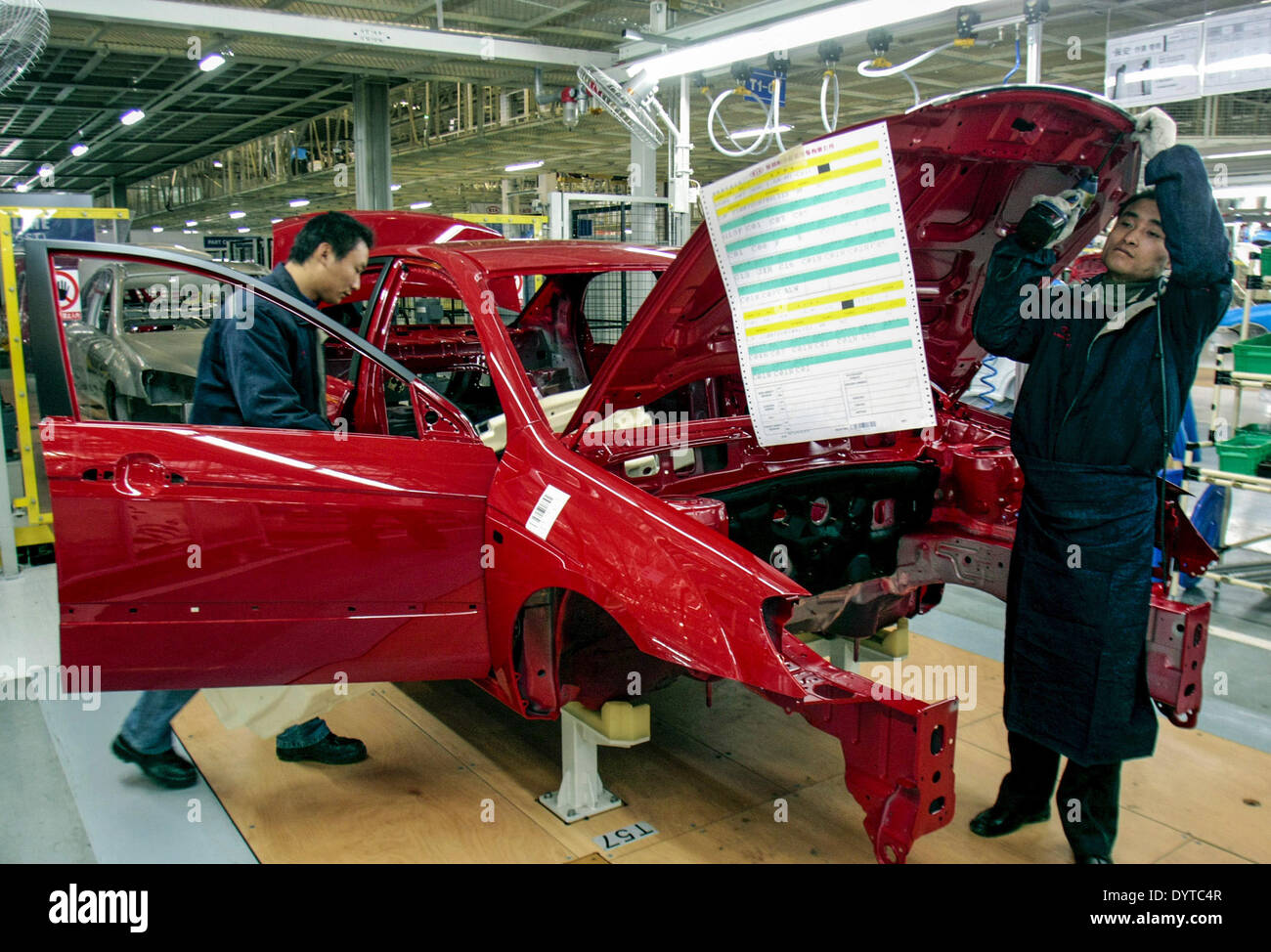 Workers assemble at a production line of KIA Motor's Cerato at YanCheng ...