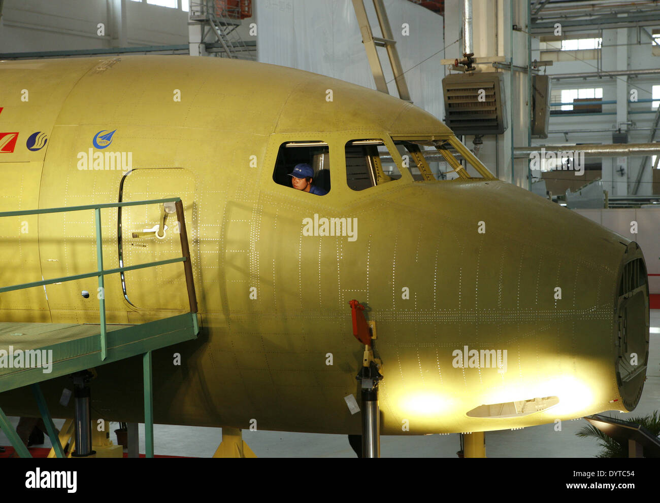 A Chinese worker looks out from the cockpit of a ARJ 21 commercial ...