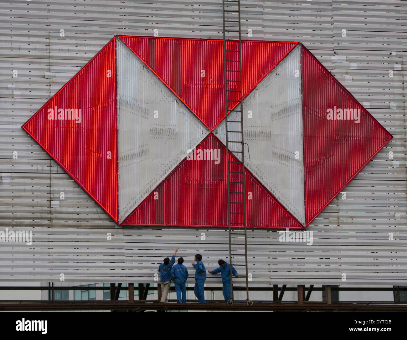 Workers at work below a gigantic neon sign of HSBC in Shanghai on 15 ...