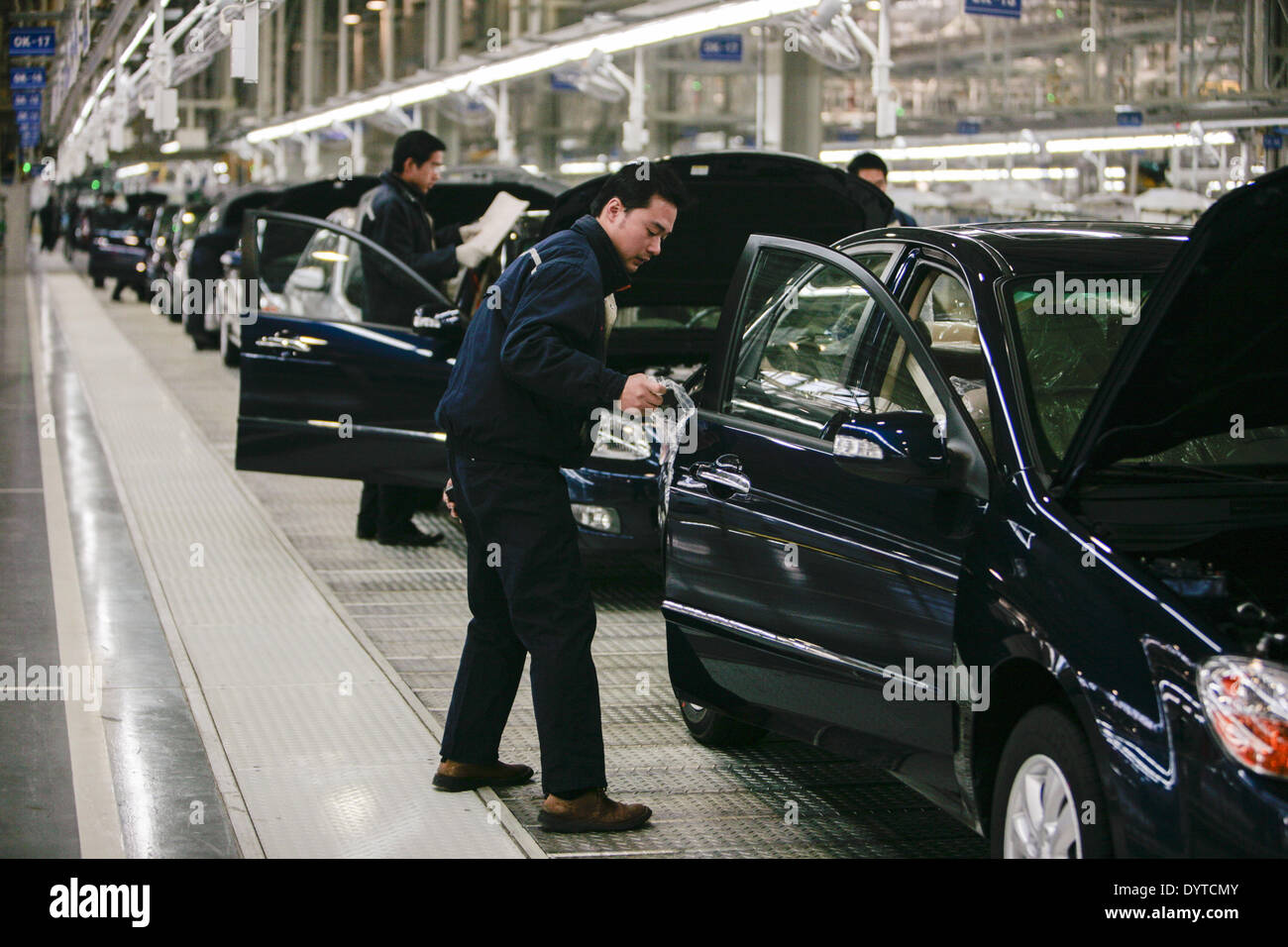 Workers assemble a vehicle on the production line of Kia Motors Corp ...