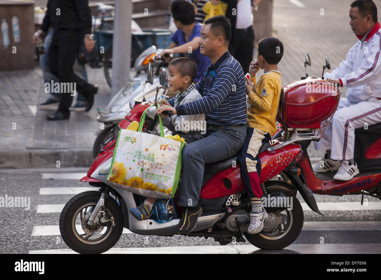 Man rides motorcycle with two kids on street hi-res stock photography ...
