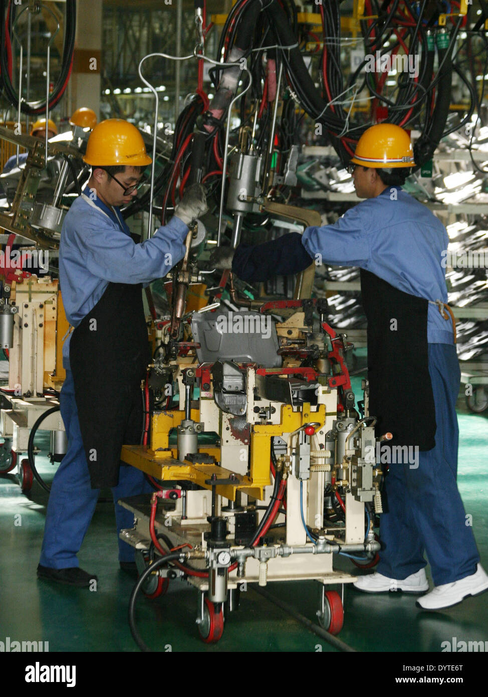 Chinese workers weld body part at a production line of economic sedan ...