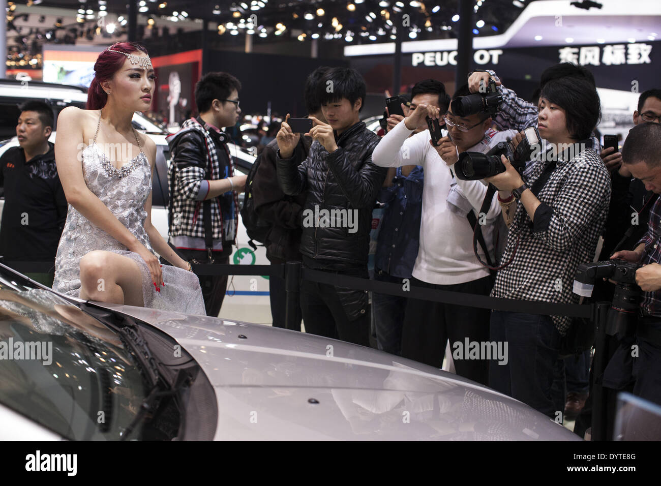Male visitors take pictures of a model poses besides a DONGFENG S30 stt ...