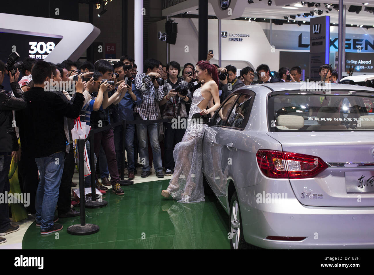 Male visitors take pictures of a model poses besides a DONGFENG S30 stt ...