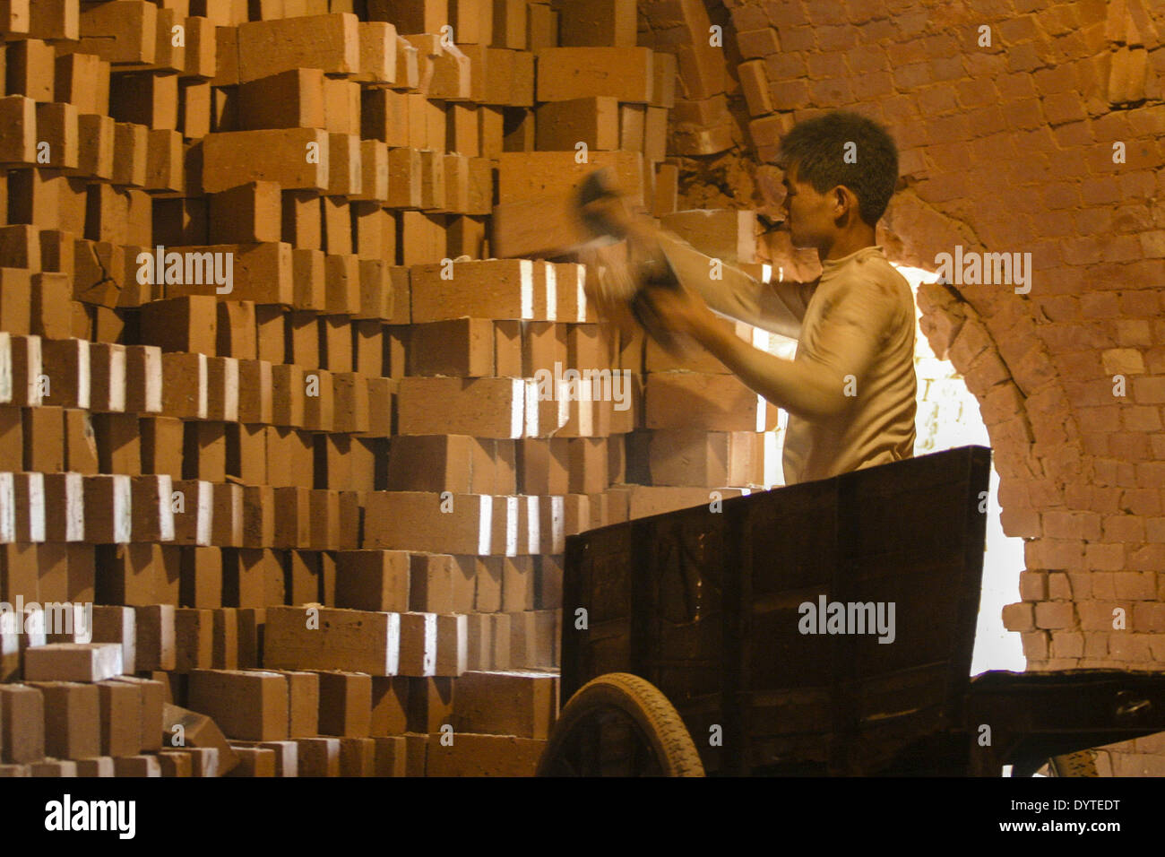 A worker places bricks inside a kiln before the burning of brick Stock ...
