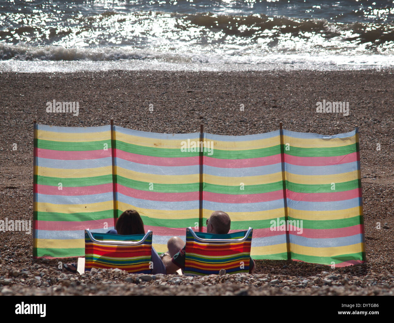 Sunbathing but sheltering from the wind on the beach in Seaford Stock ...