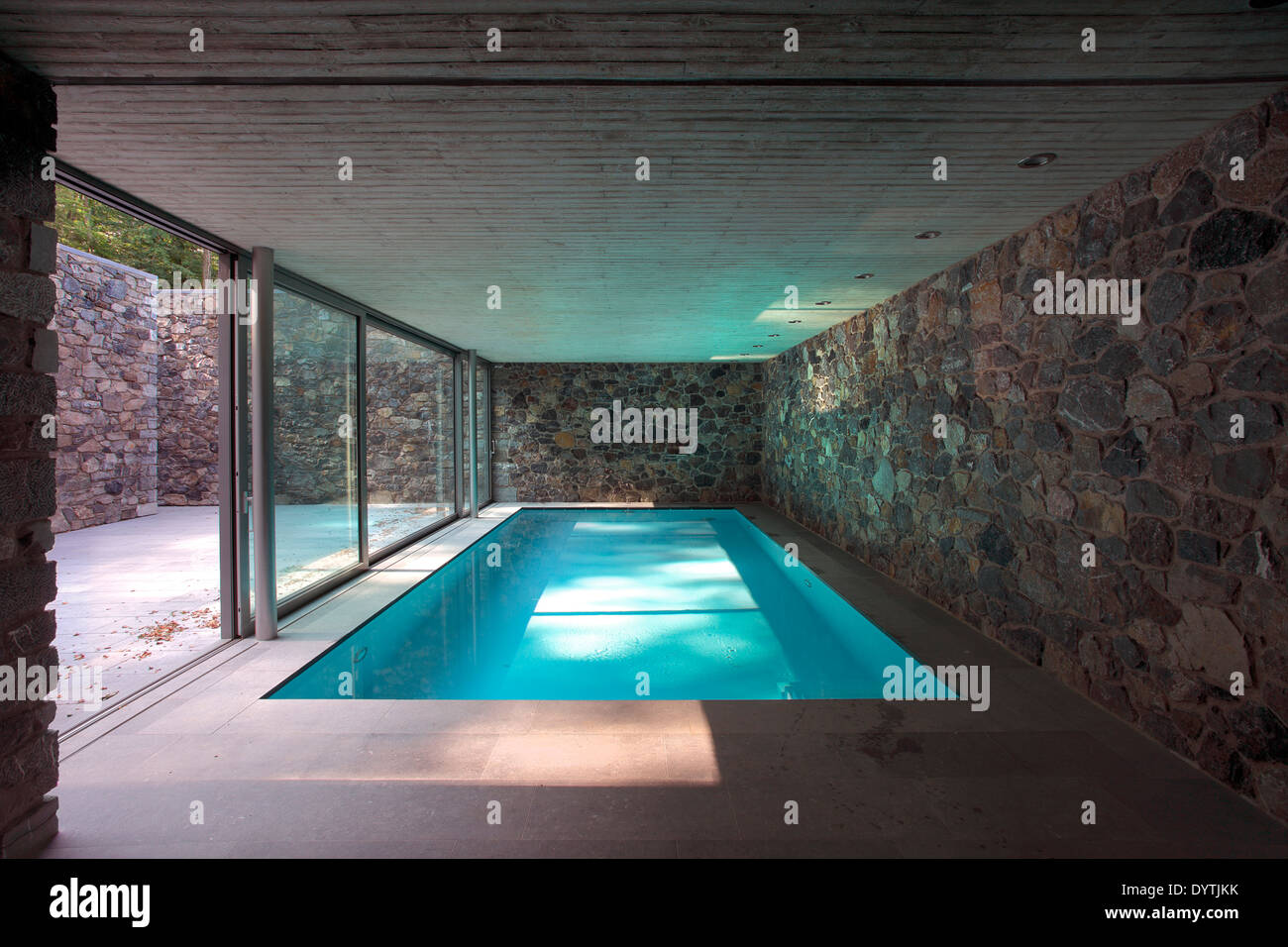 Indoor swimming pool with stone surround and glass doors Stock Photo ...