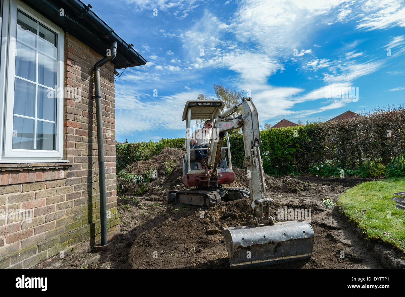 Excavating a lawn prior to laying a driveway using a micro compact ...