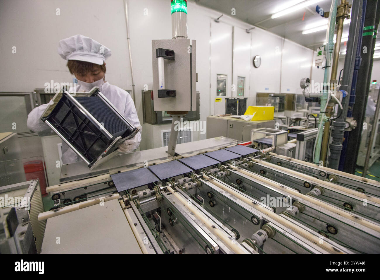 A worker examines wafer at the Texturing stage with machinery made by ...