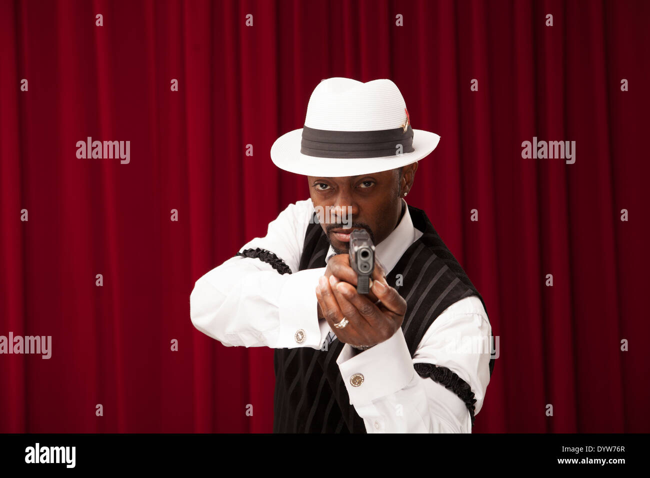 african american gambler dressed in retro mobster suit pointing gun ...