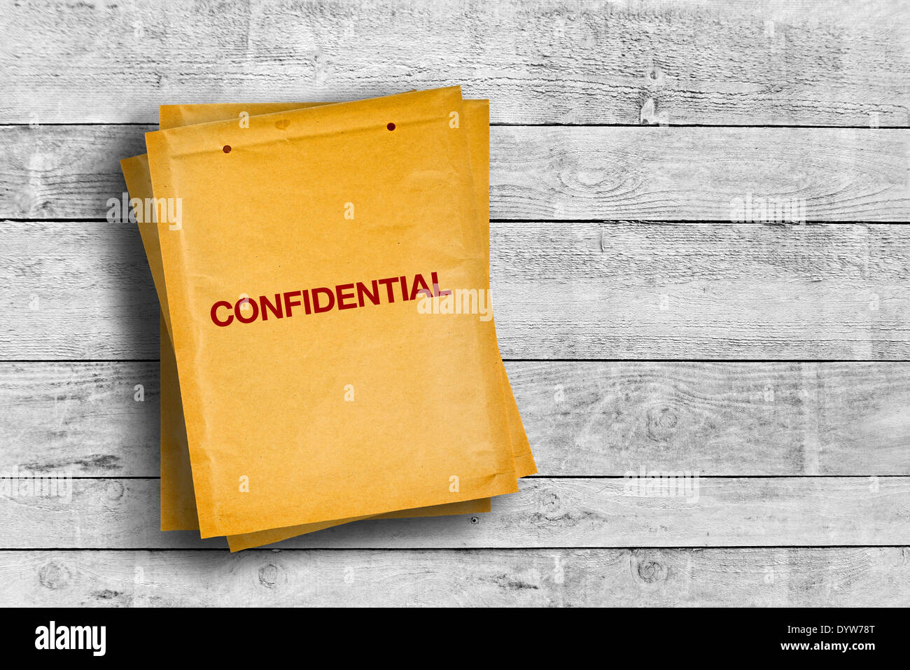Confidential stamp on yellow envelope placed on wooden table Stock ...