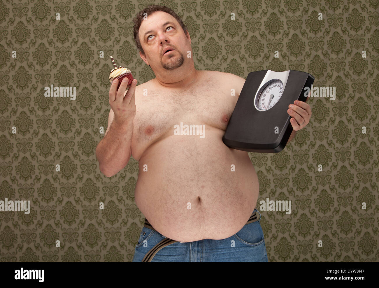 overweight male holding scales while upset with the healthy lifestyle ...