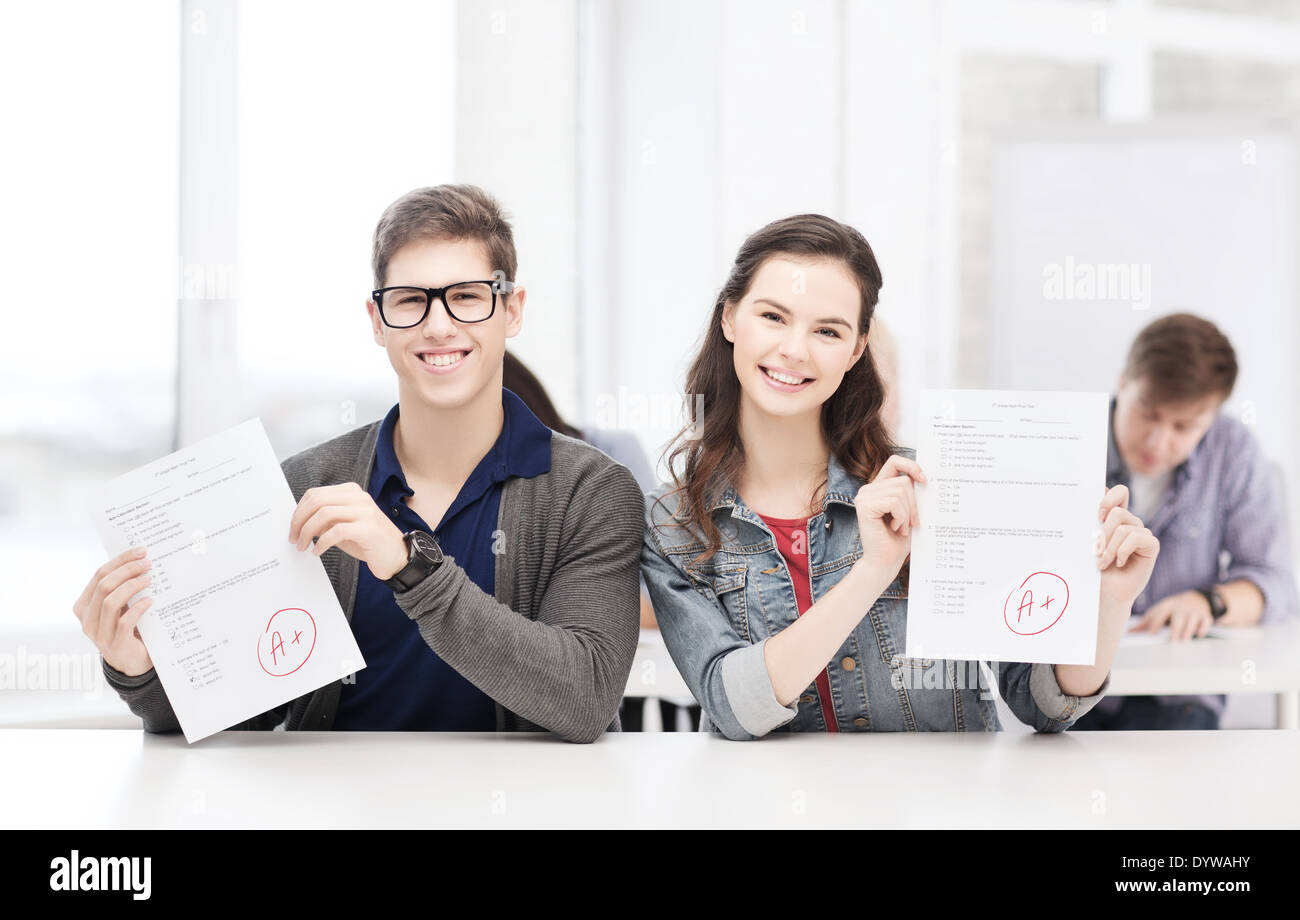 two teenagers holding test or exam with grade A Stock Photo - Alamy