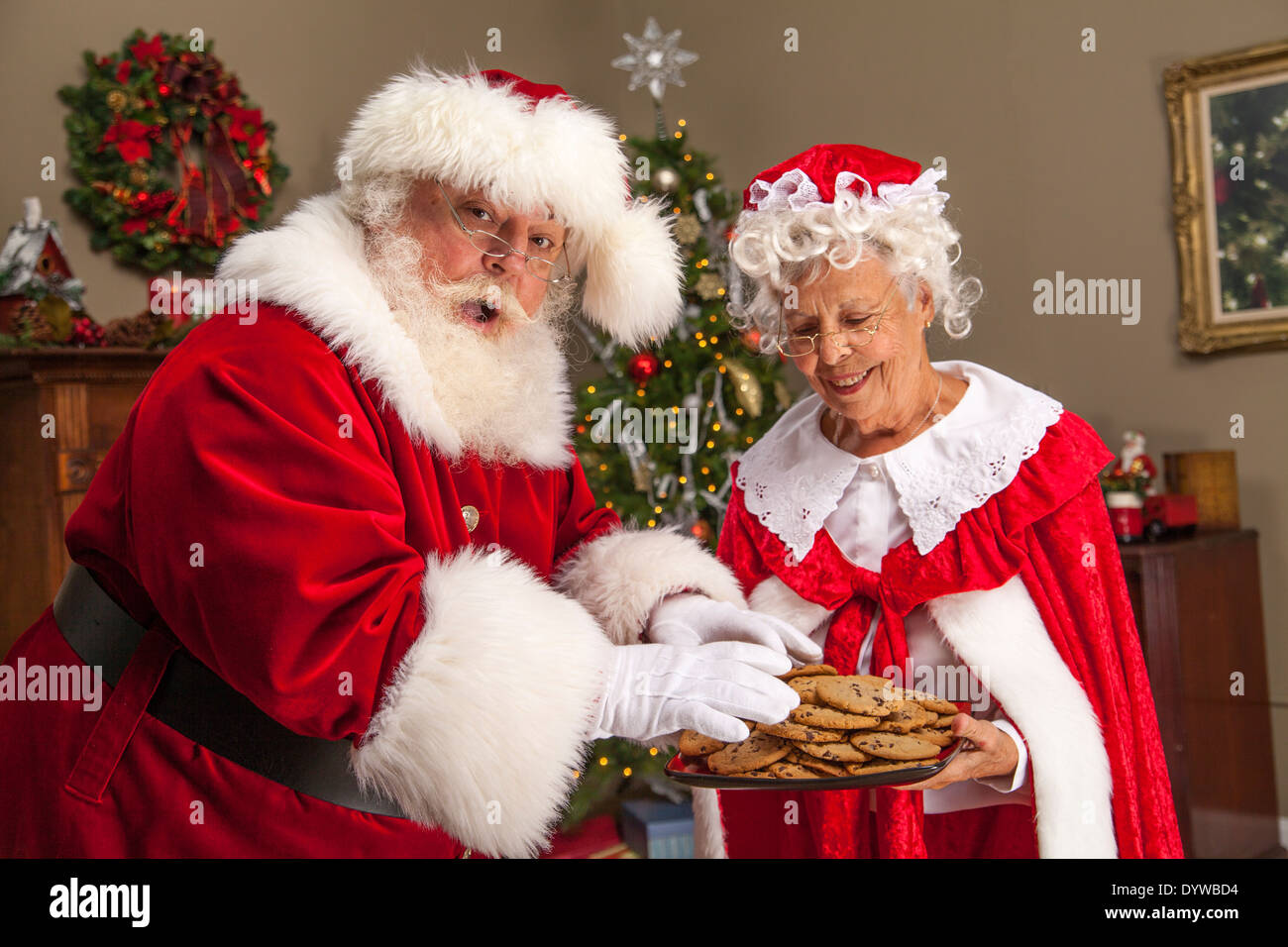 color, horizontal image of Mrs Claus giving Santa a plate of cookies ...