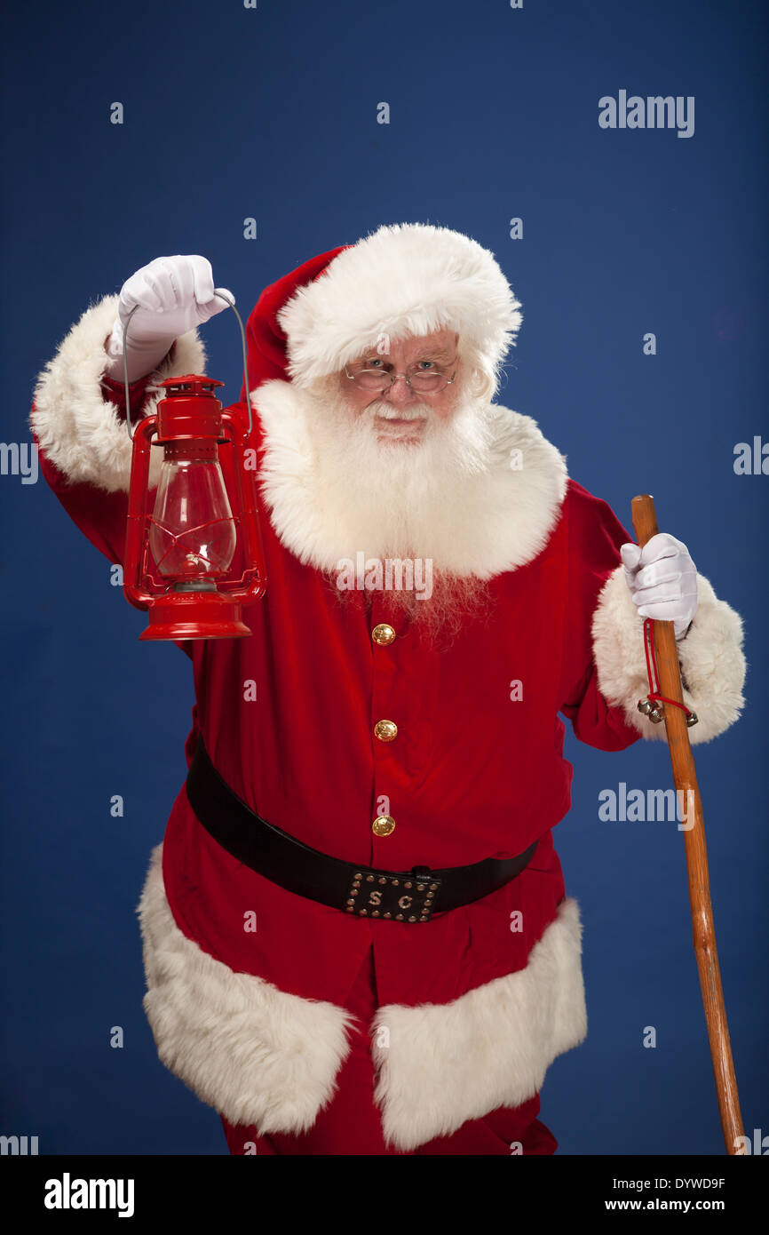 vertical, color image of the real santa holding a lantern and a walking ...